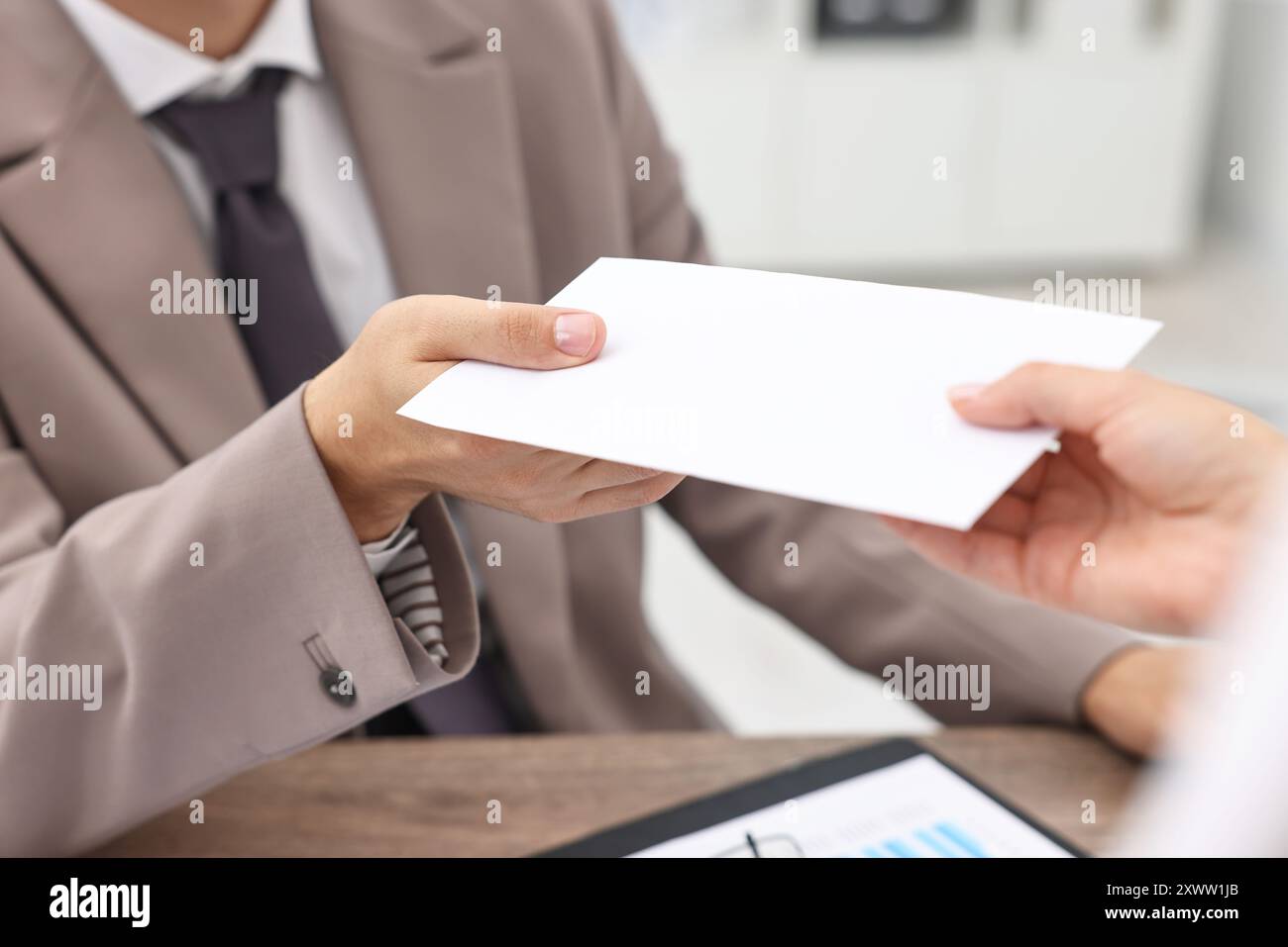 Employee receiving envelope with salary from boss in office, closeup ...