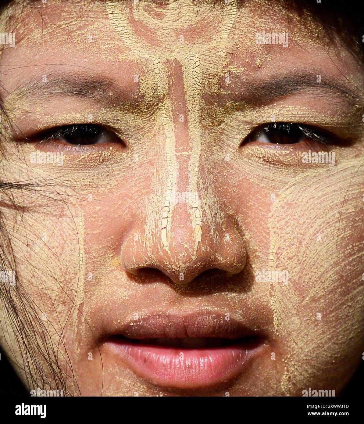 A Burmese girl wearing Thanaka ( yellow powder makeup ) on her face Stock Photo - Alamy