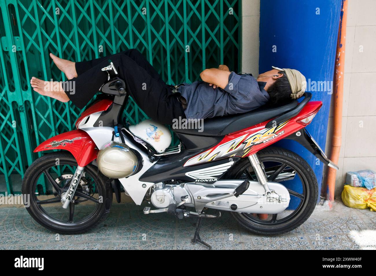 A Vietnamese man napping on his motorcycle. Saigon, Vietnam Stock Photo ...