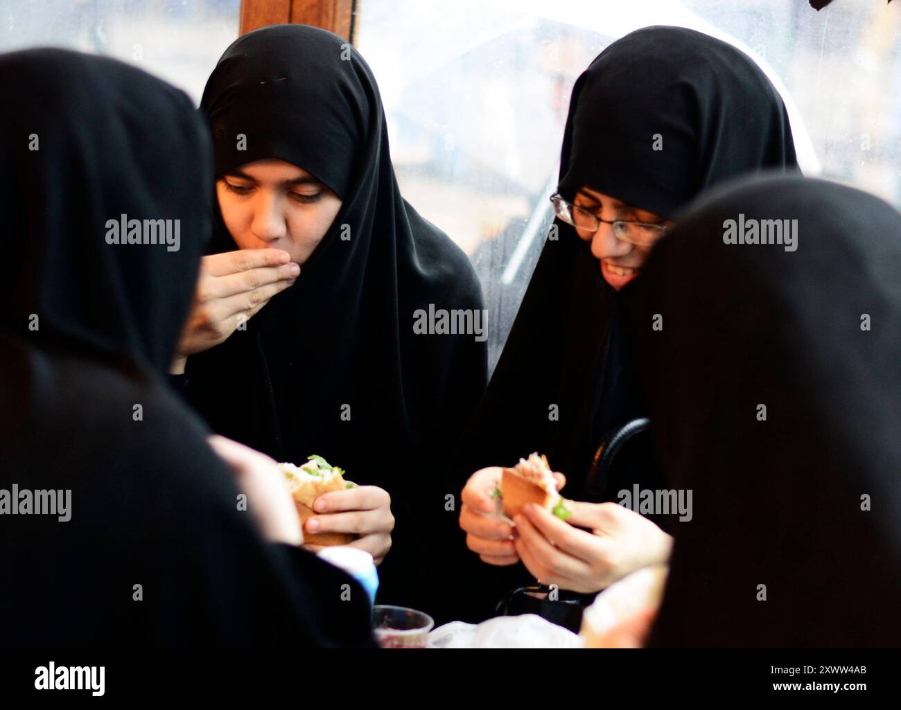 Traditional Muslim Turkish woman enjoying a fish sandwich by the Galata ...