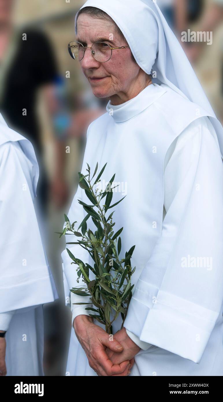 A Catholic nun holding an olive branch during the Palm Sunday ...