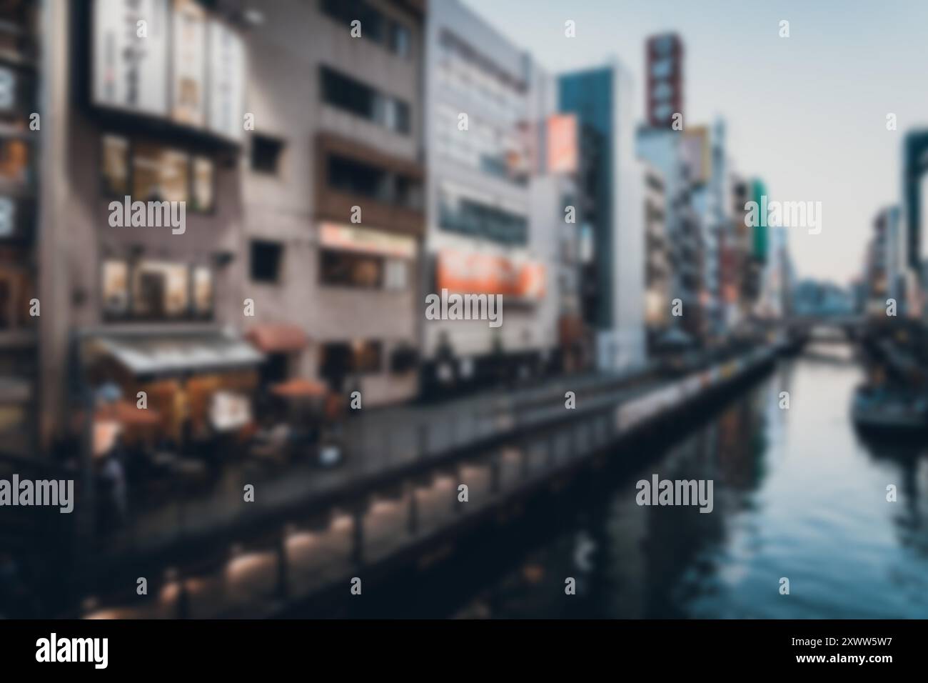 Blurry view of a canal in a Japanese city with buildings lining the ...