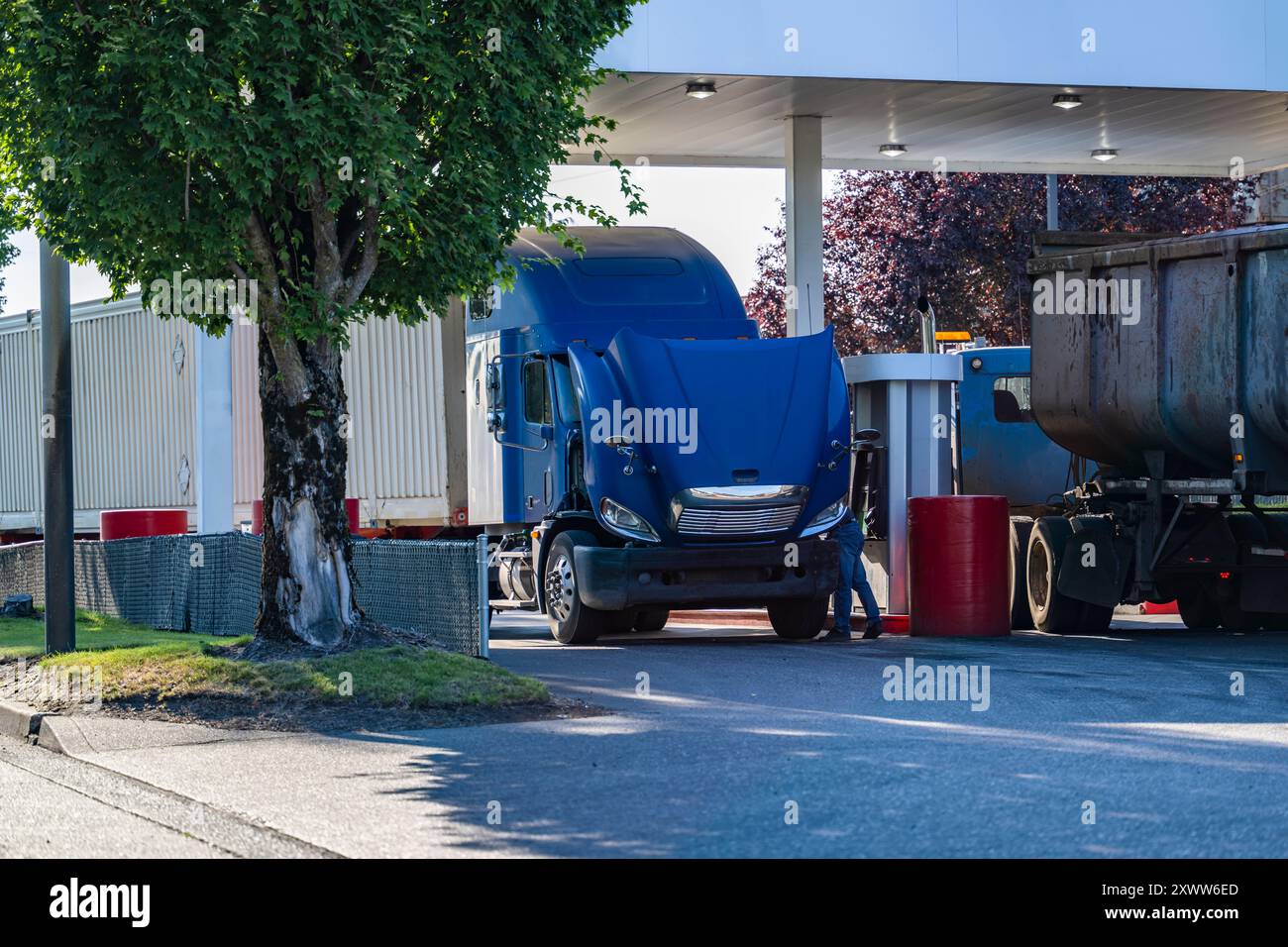 Industrial grade blue big rig semi-truck with open hood and container ...
