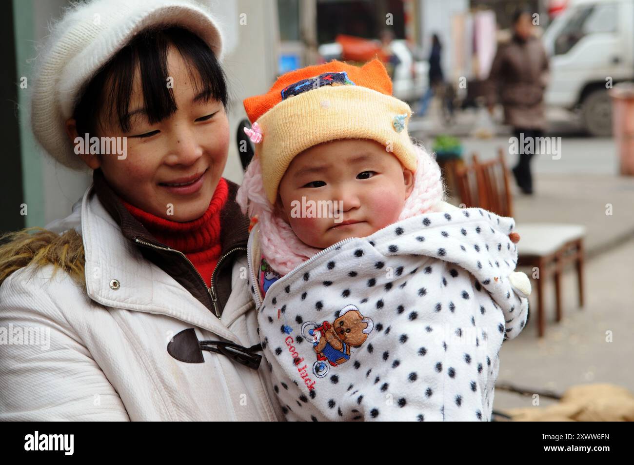 A smiling Chinese woman with her baby in the streets of Nanjing, China ...