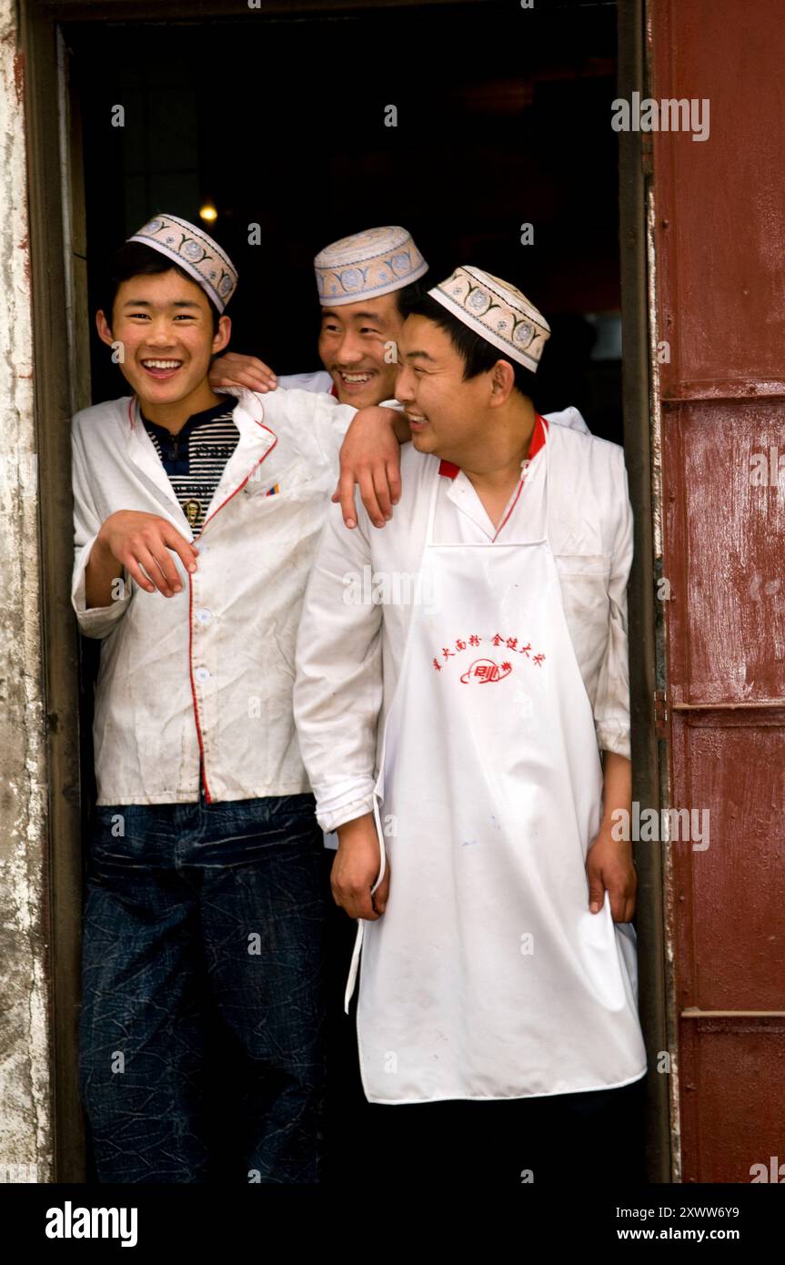 A group of Chinese muslim cooks enjoy a laugh at the door of the ...
