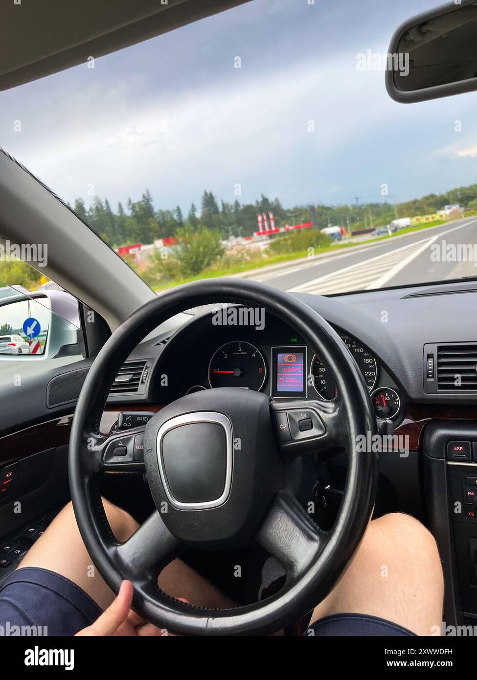 a man in shorts is driving a car. verticall Stock Photo - Alamy