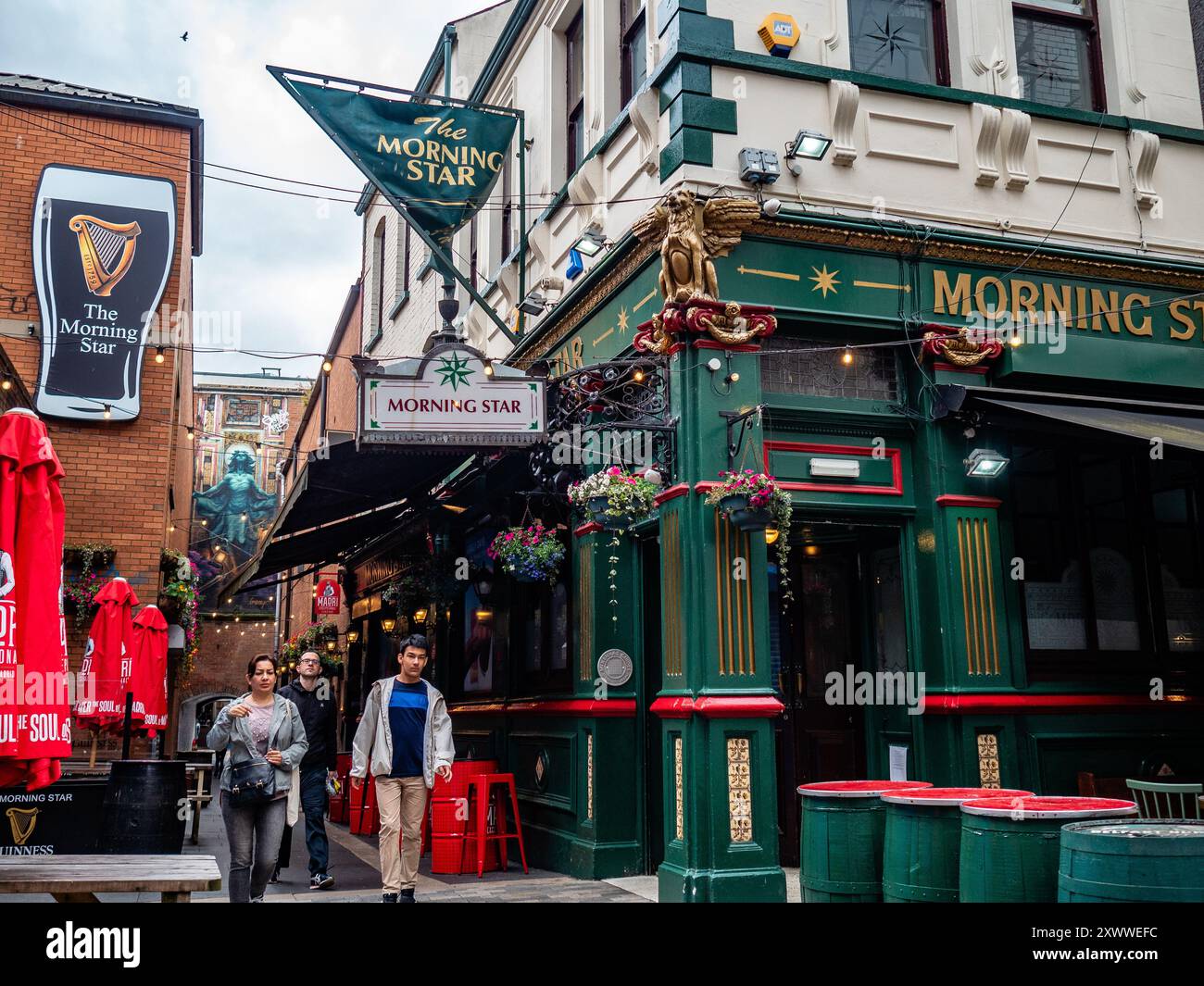 People walk next to a traditional Irish pub. Belfast's visitor economy ...