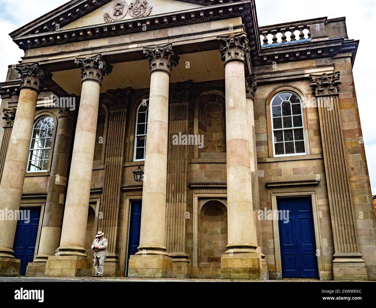 A man in a white suit is seen waiting outside of a church. Belfast’s ...