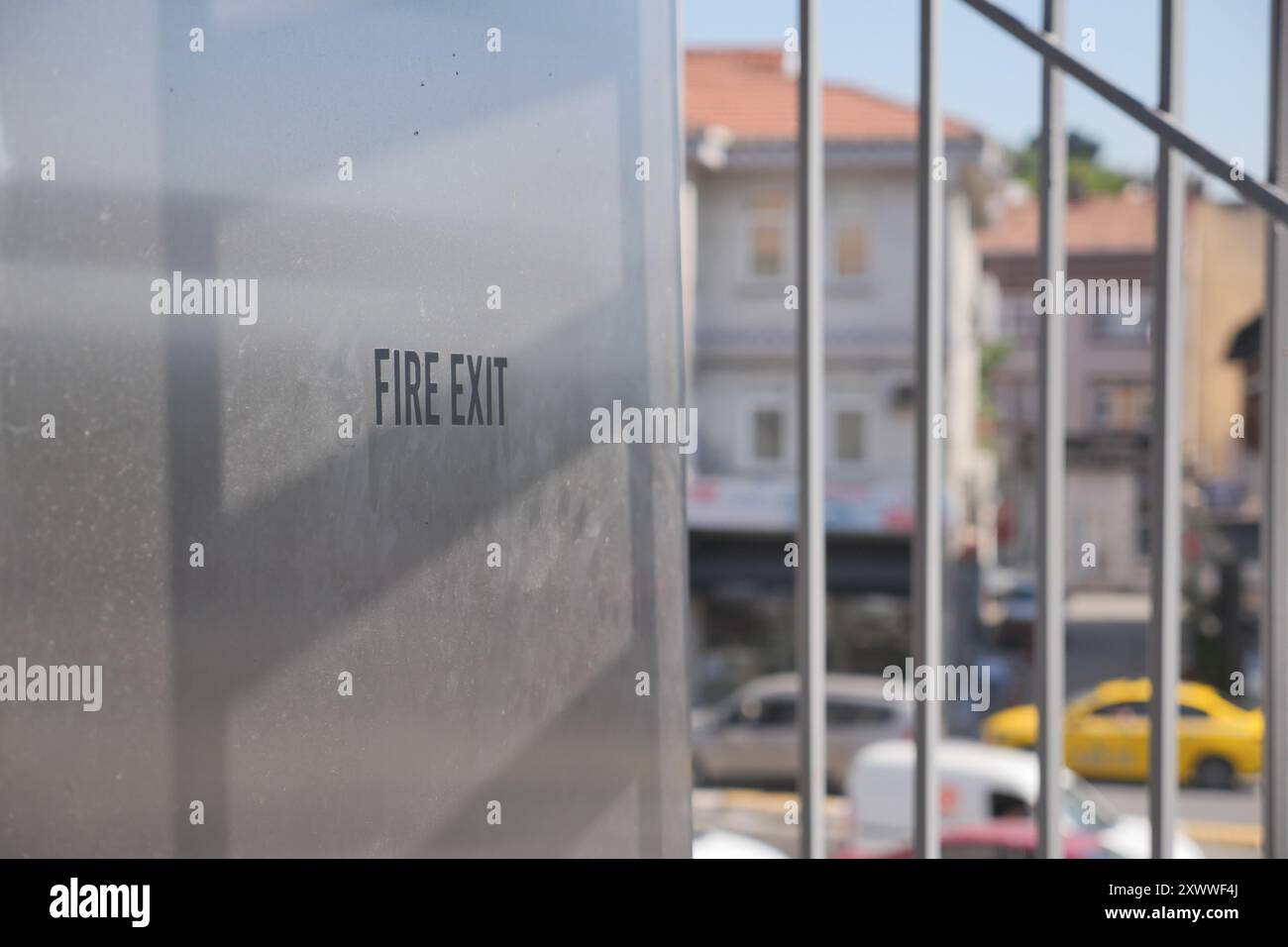 A Fire Exit Sign Positioned Adjacent to a Bustling Urban Street View ...