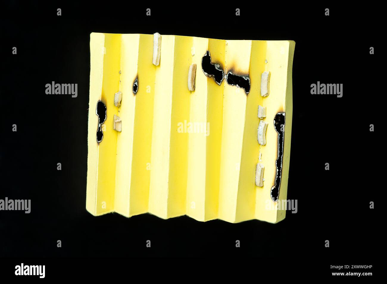 A yellow piece of paper with black burn marks on it Stock Photo - Alamy