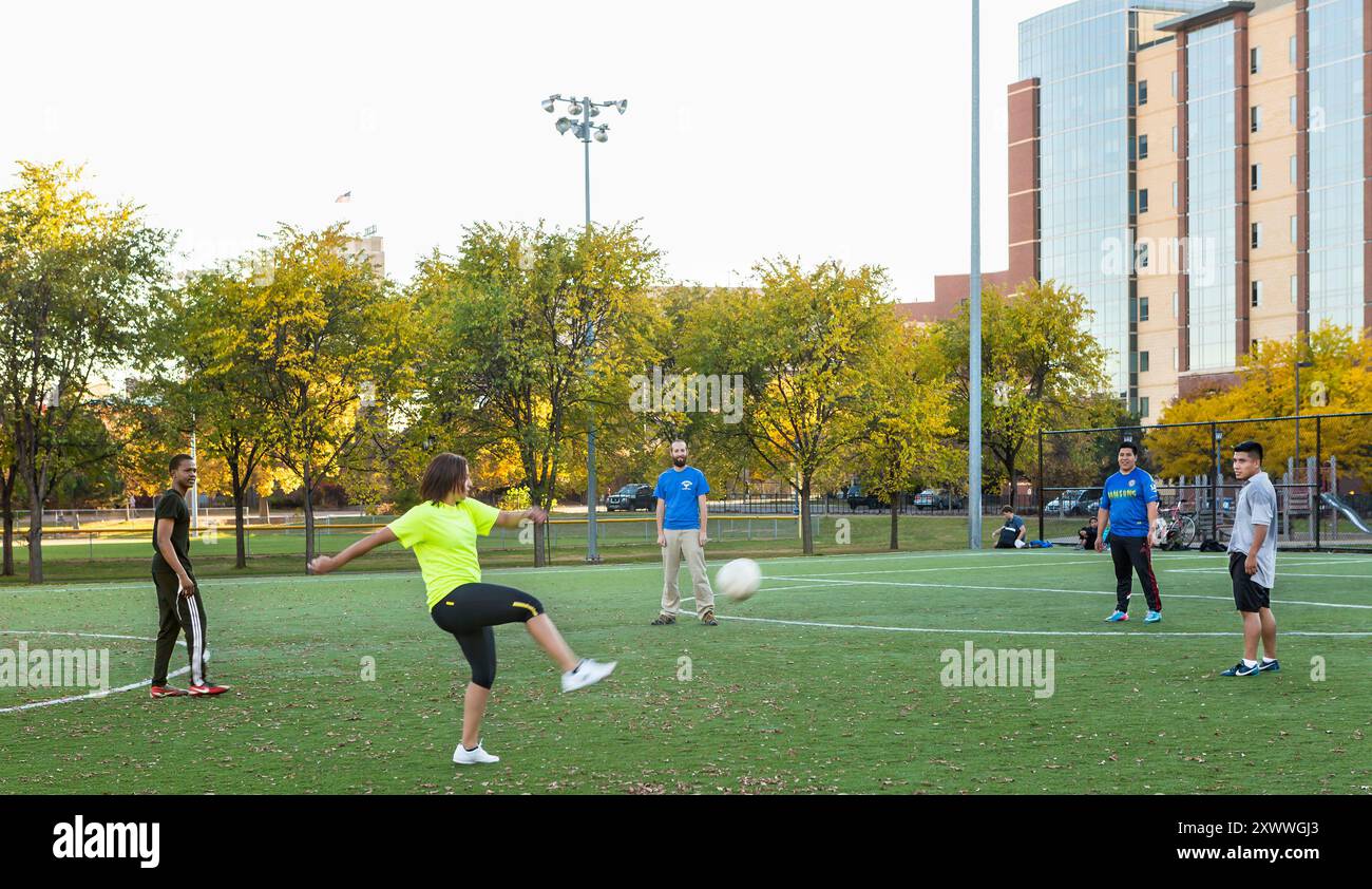 Five people kick soccer ball around on soccer field Stock Photo - Alamy