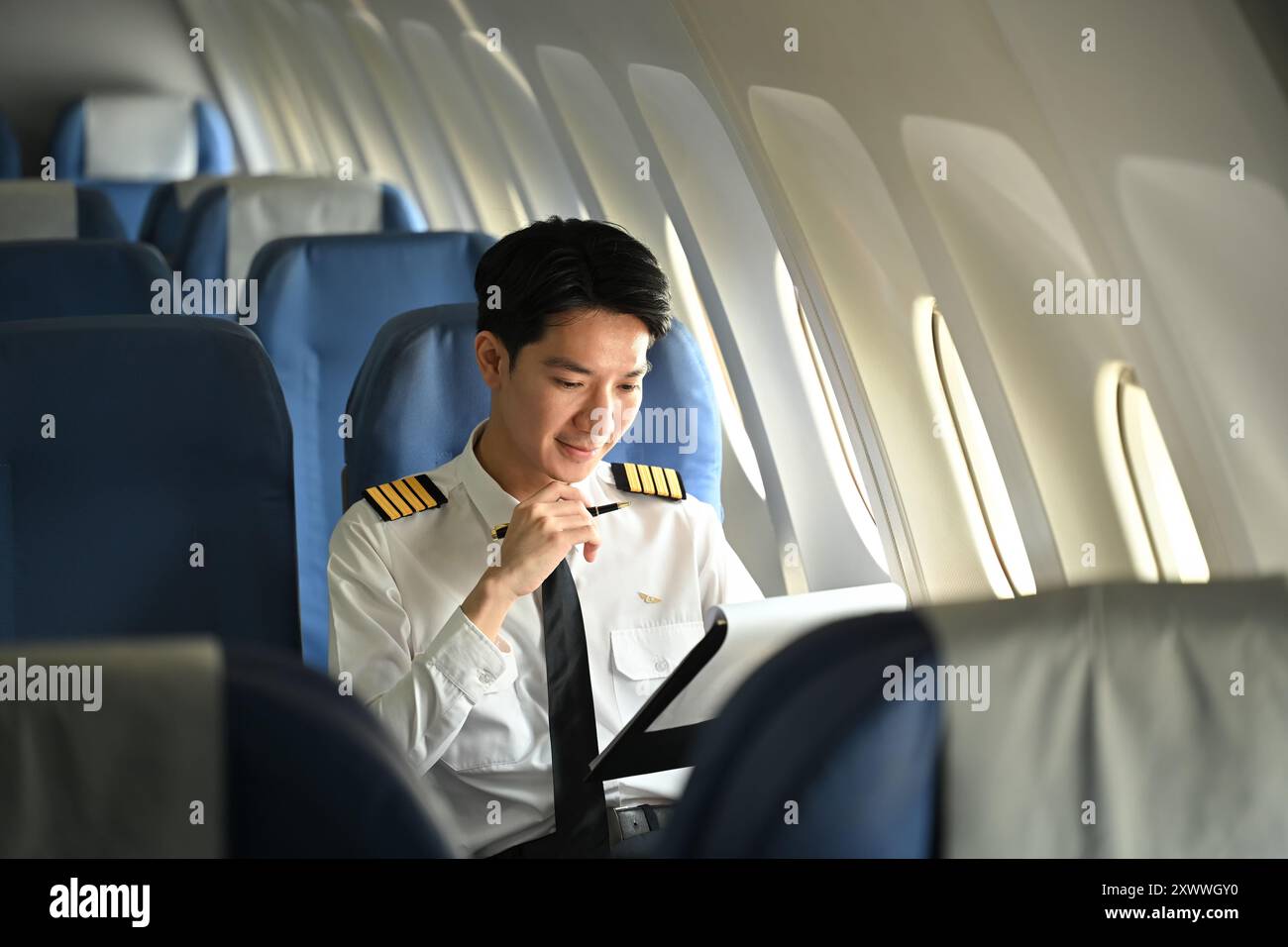 Concentrated pilot reviewing flight plans or other important ...