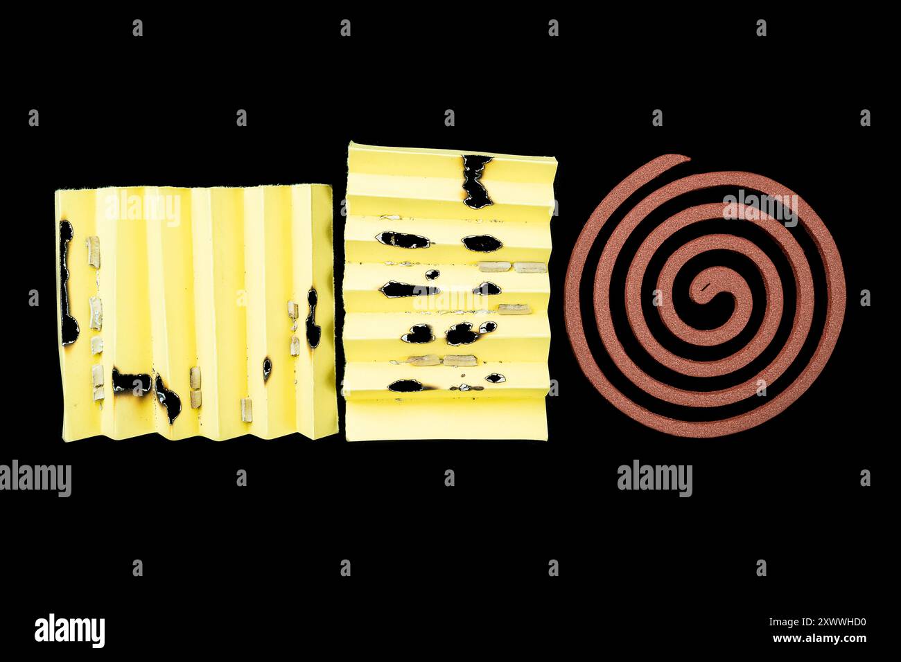 A yellow piece of paper with a mosquito coils on it. A brown object is ...