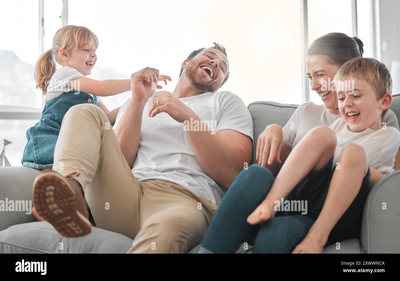 Couch, parents and children with laugh for tickle, connection and ...