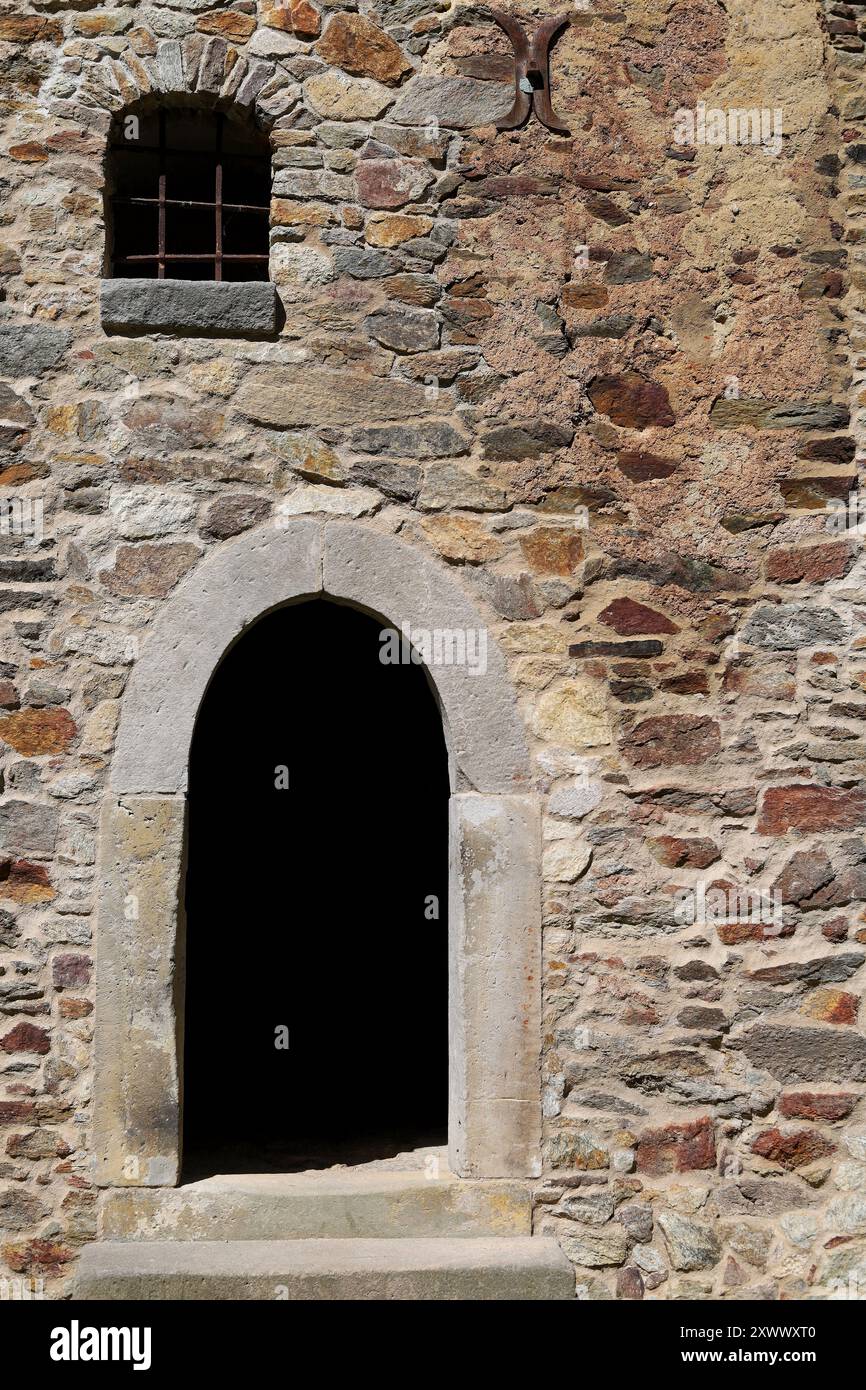 Stone wall of a medieval castle with a window and the entrance to the ...