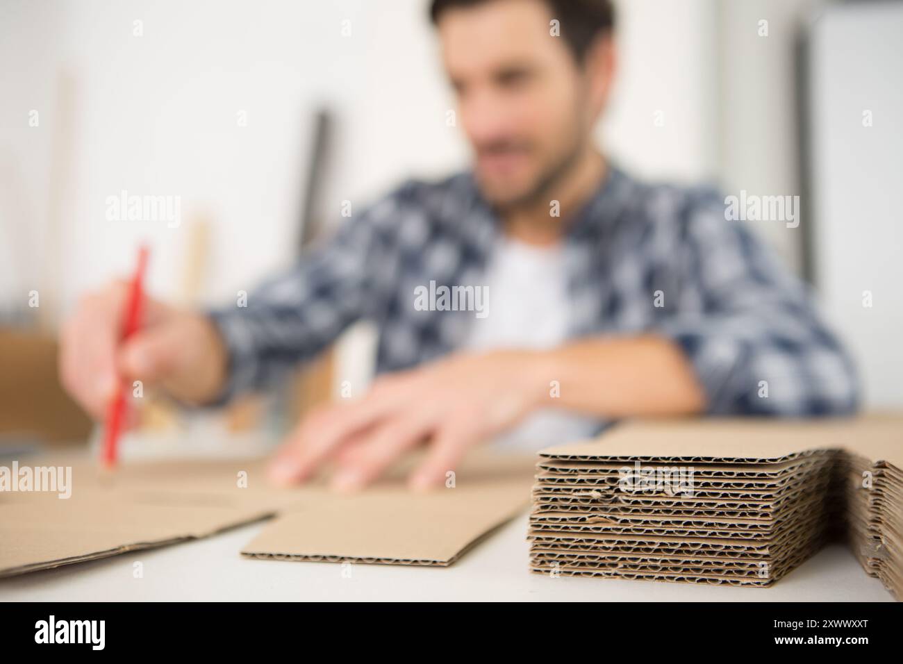 male worker drawing a design on cardboard Stock Photo - Alamy