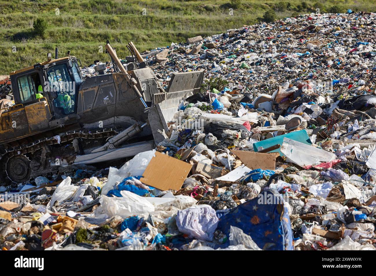 Heavy machinery shredding garbage in an open air landfill. Waste Stock ...