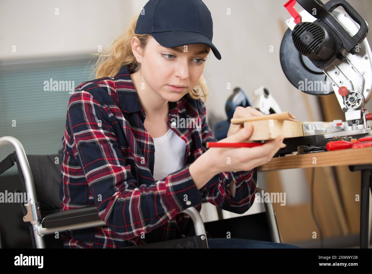 a female carpenter in wheelchair working on wood workshop Stock Photo ...