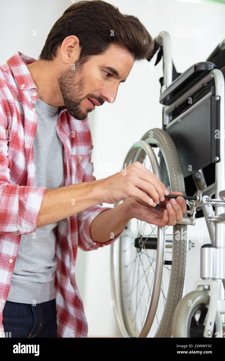 a man is fixing a wheelchair Stock Photo - Alamy