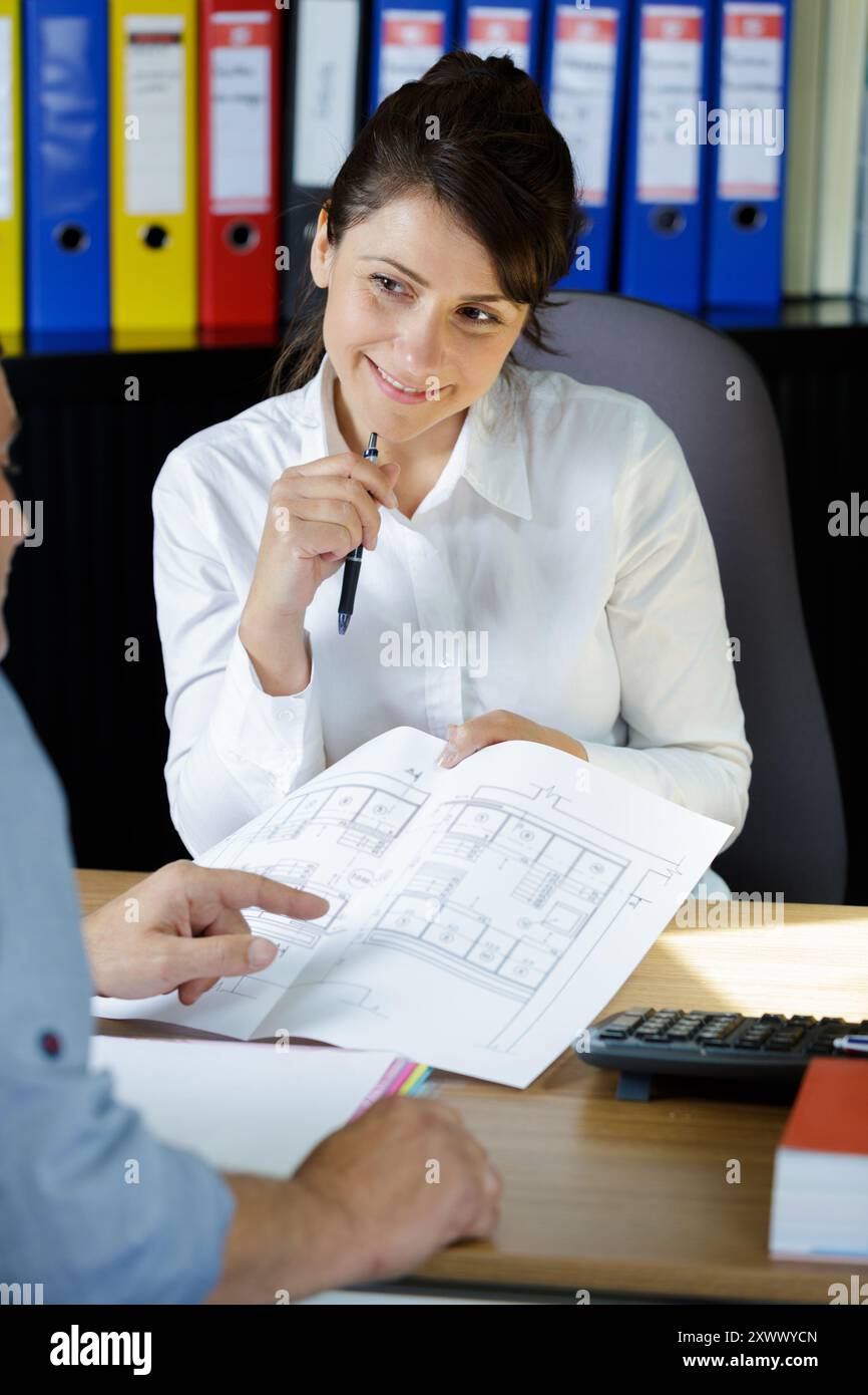 architect woman with a plans and customer Stock Photo - Alamy