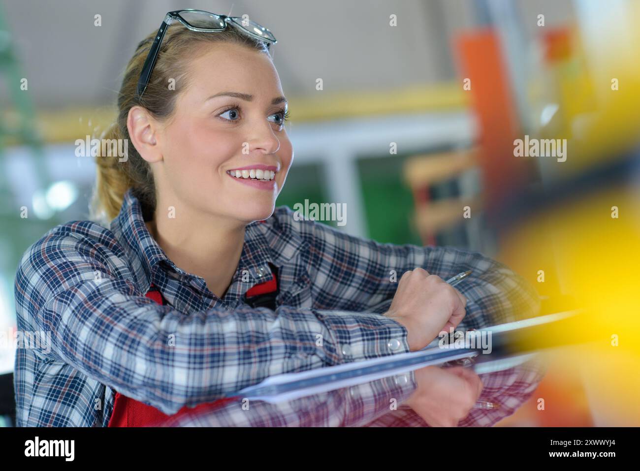 happy female worker leaning on reflective surface Stock Photo - Alamy