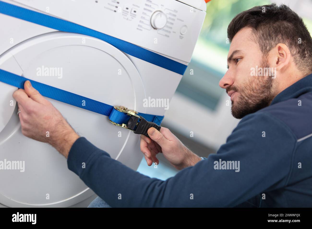Repairman carrying washing machine hi-res stock photography and images ...