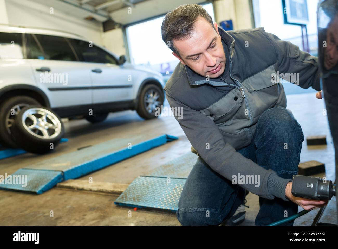 mechanician changing wheel in the auto service garage Stock Photo - Alamy