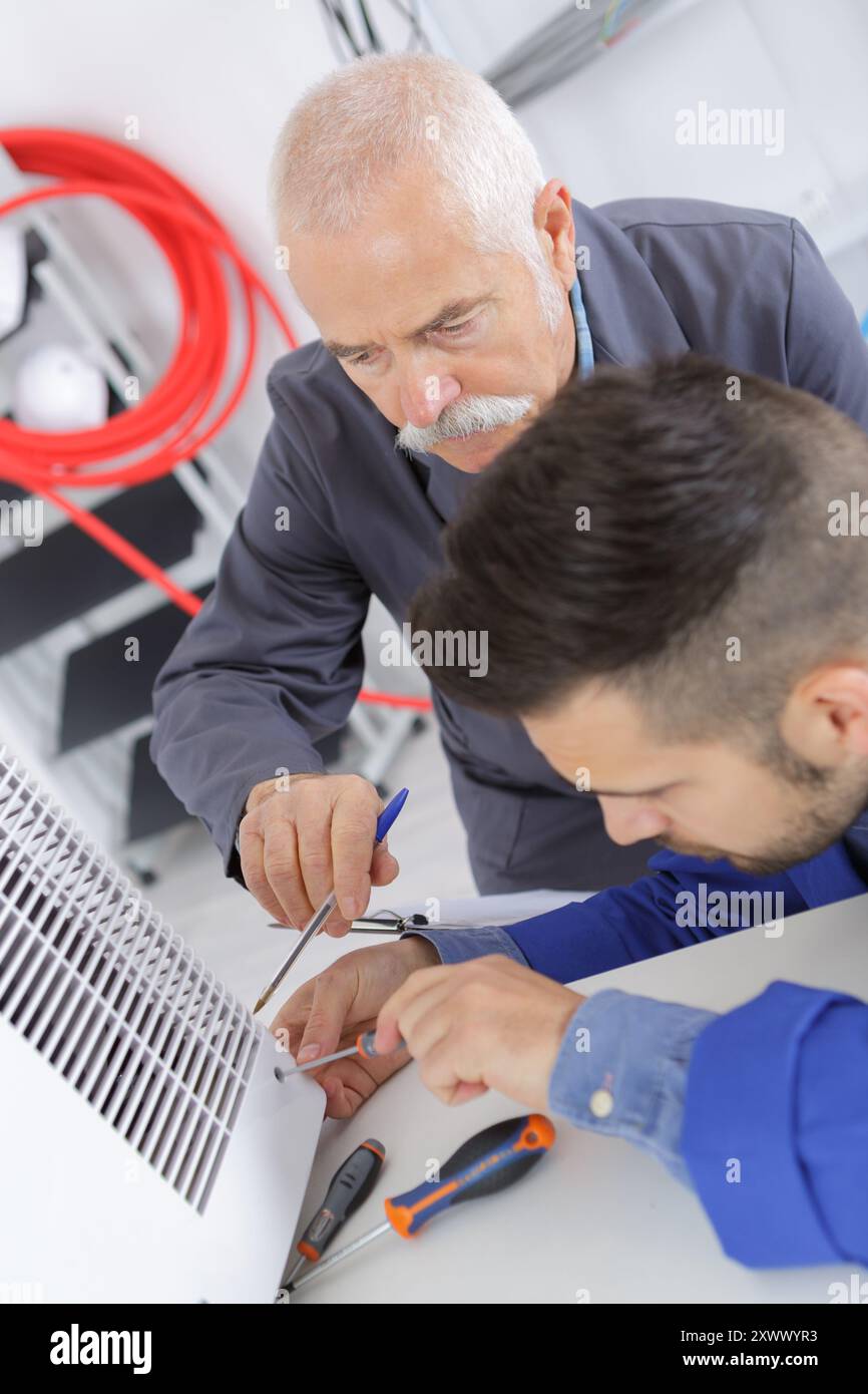 a man fixing a radiator Stock Photo - Alamy