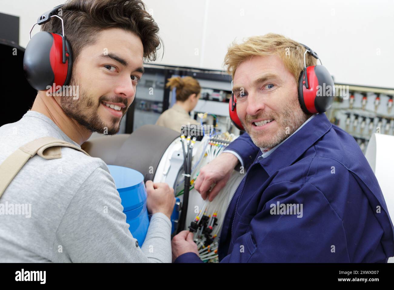 two electricians working in a factory Stock Photo - Alamy