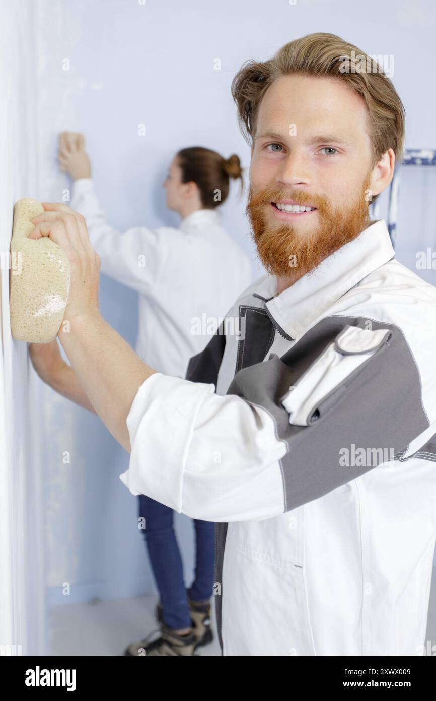 young decorator finishing wall with sponge float Stock Photo - Alamy