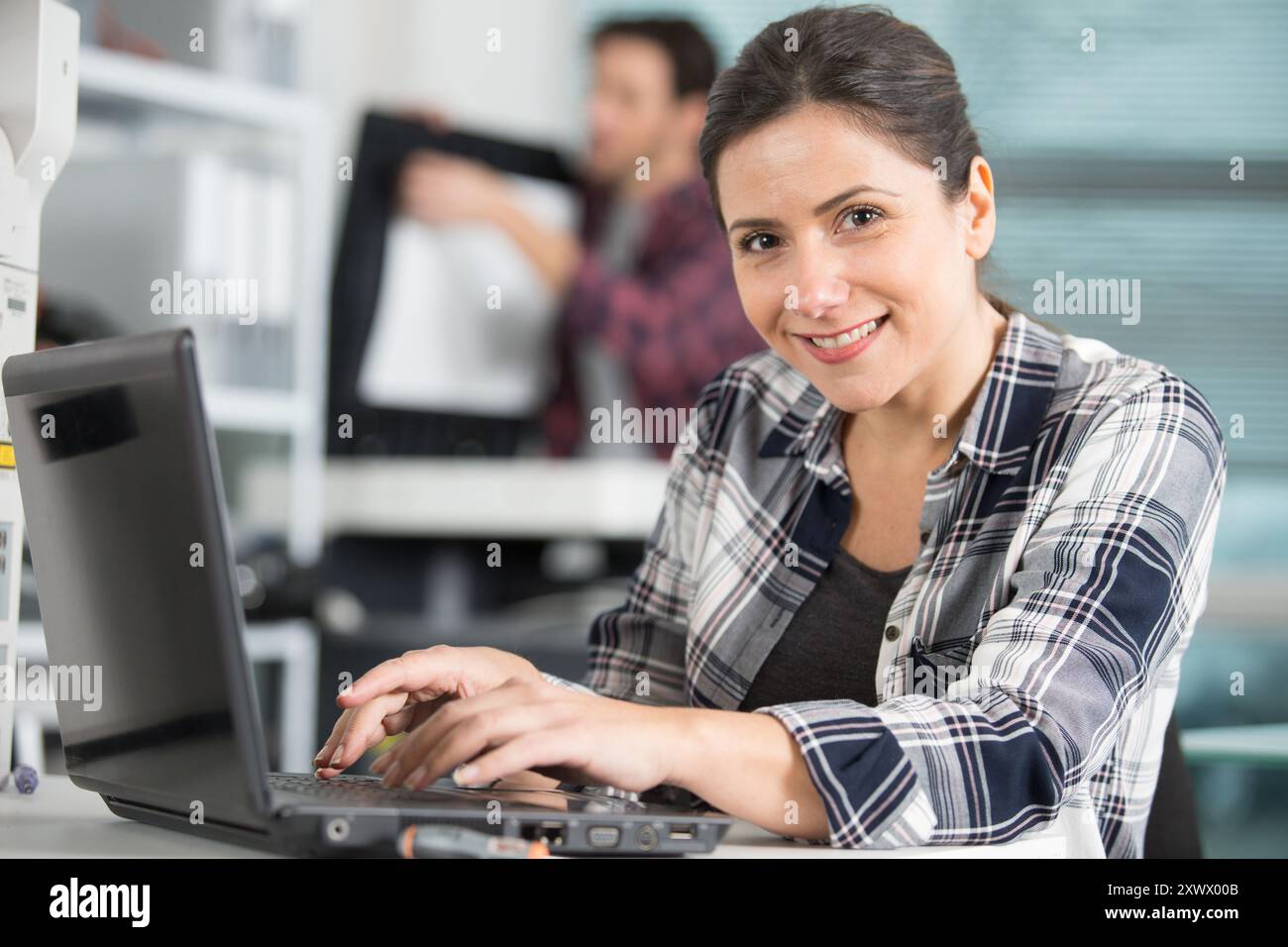 happy female technician using laptop to analyse server Stock Photo - Alamy