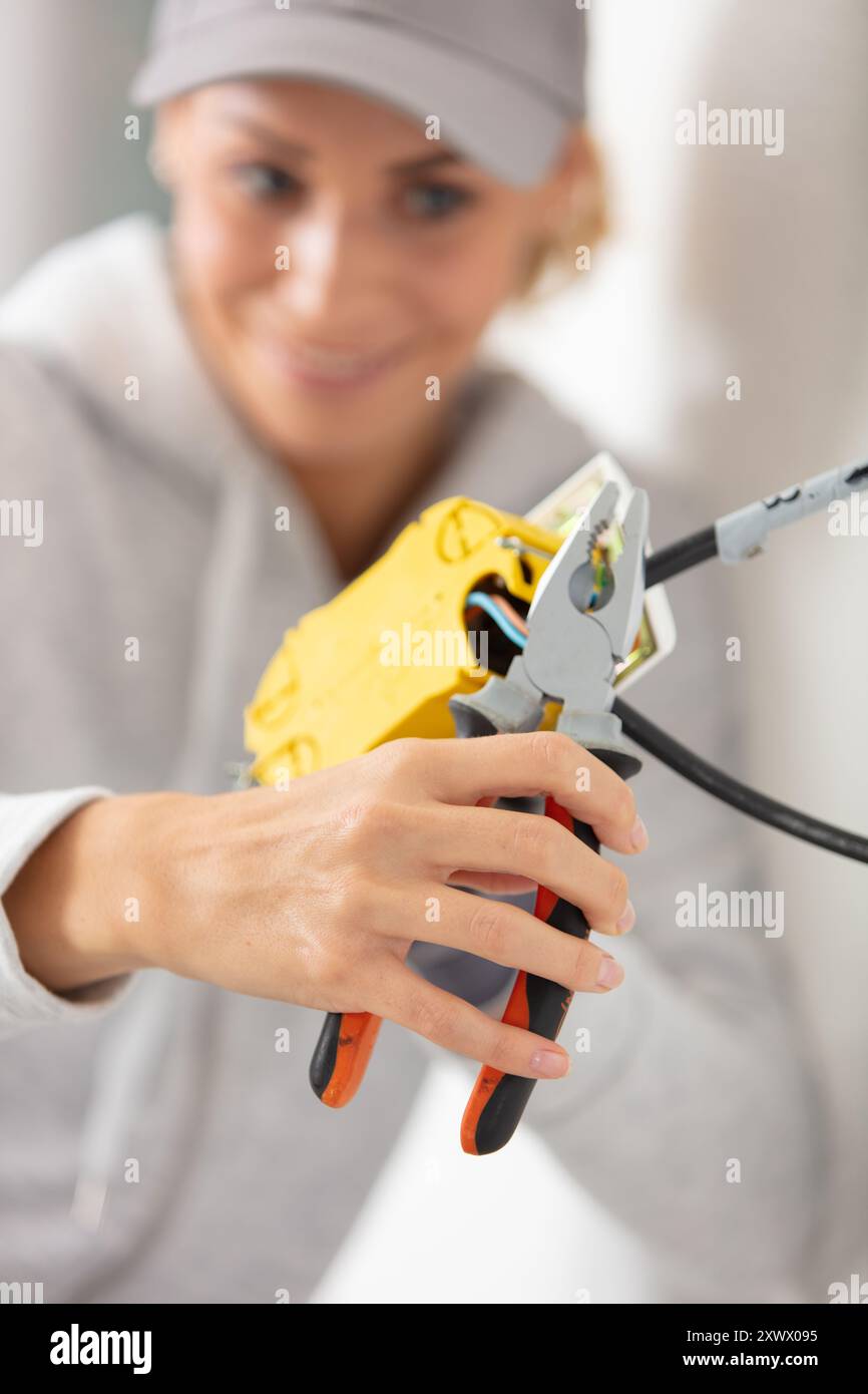 young tradeswoman installing electrical wiring Stock Photo - Alamy