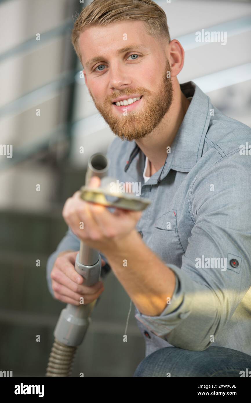 happy man fitting vacuum cleaner attachment Stock Photo - Alamy
