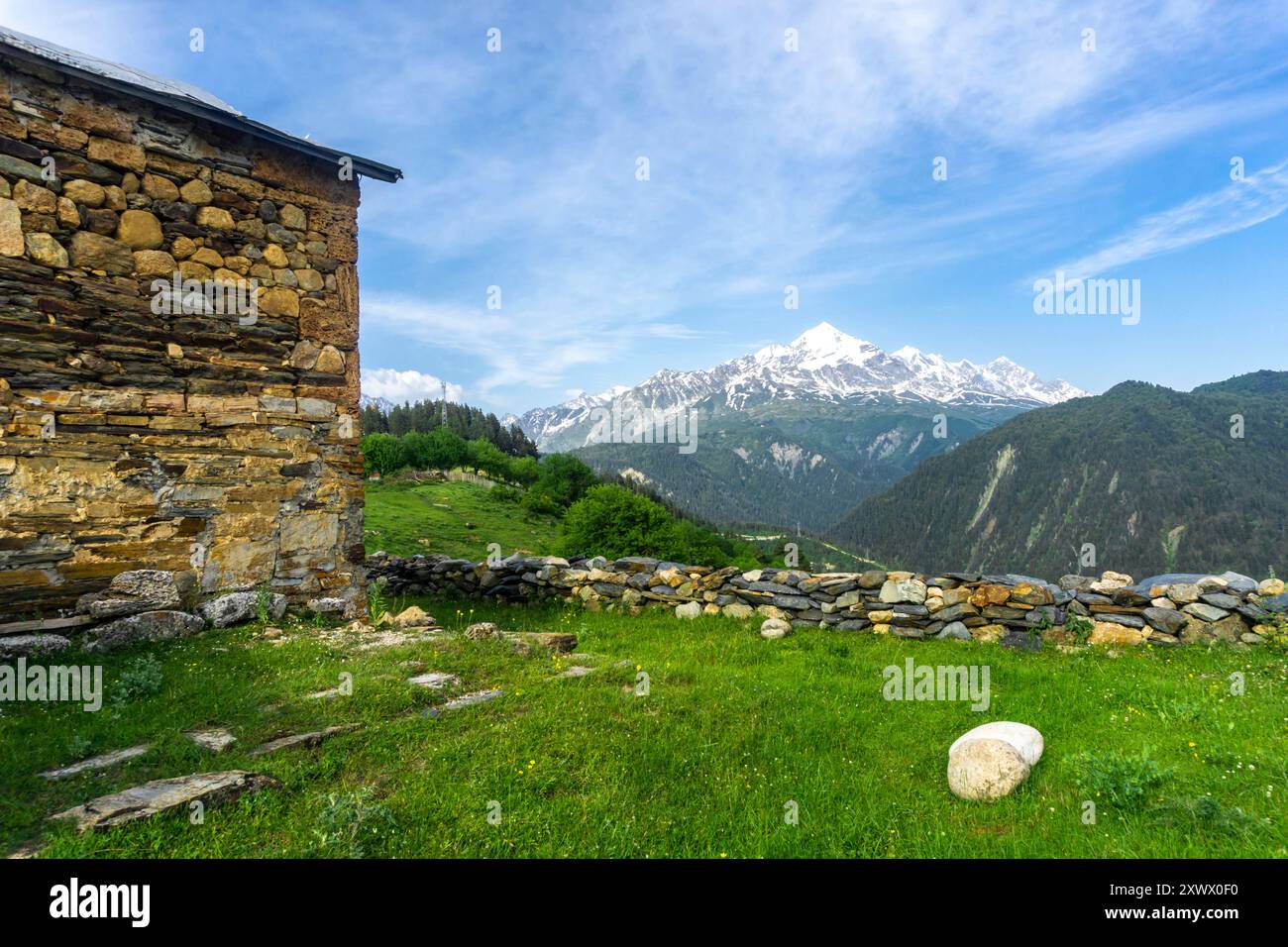 The medieval stone basilica stands on a green field surrounded by a ...