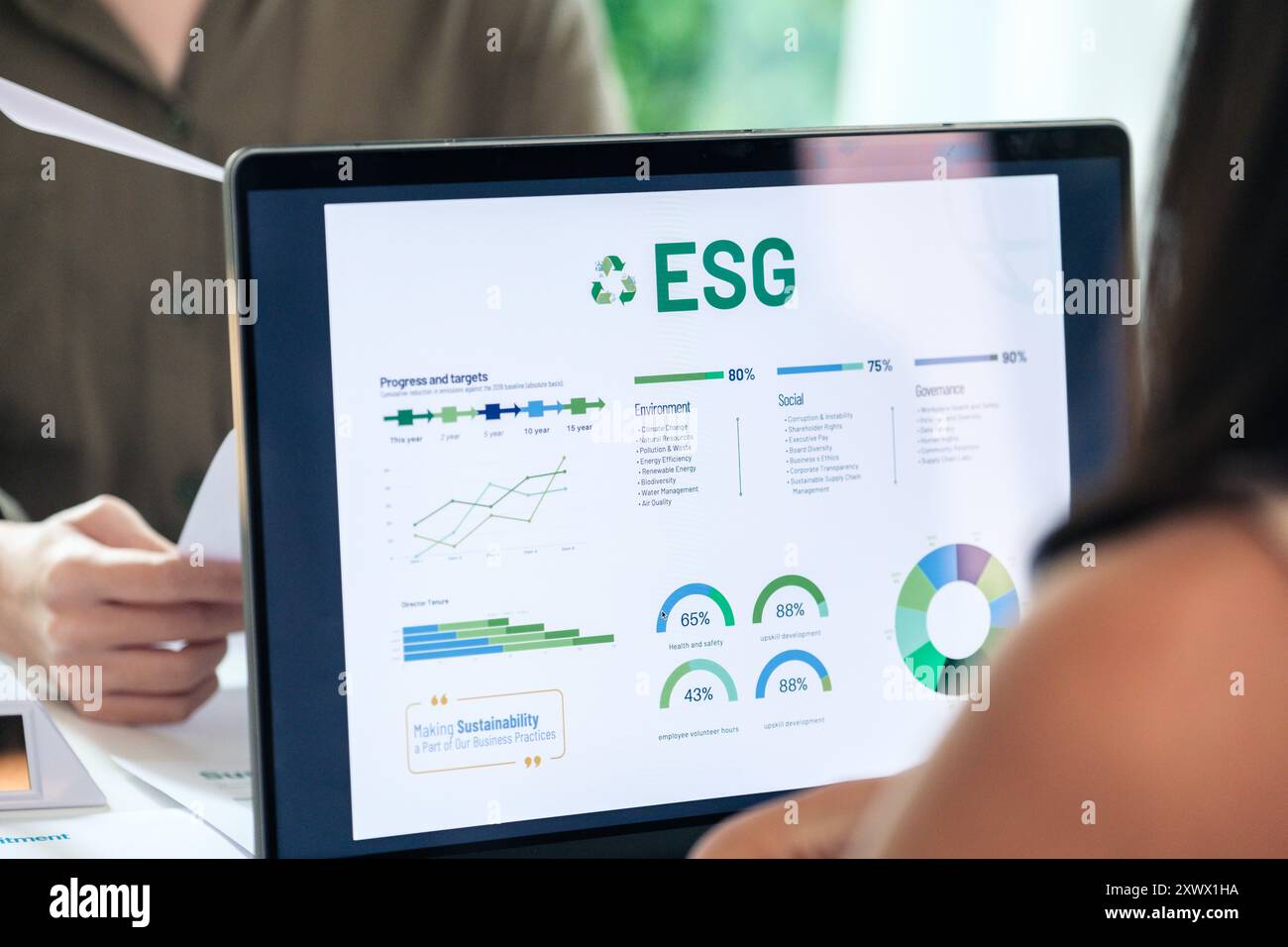ESG ( environment, social,governance) recycle sign on laptop screen with carbon free chart board ...