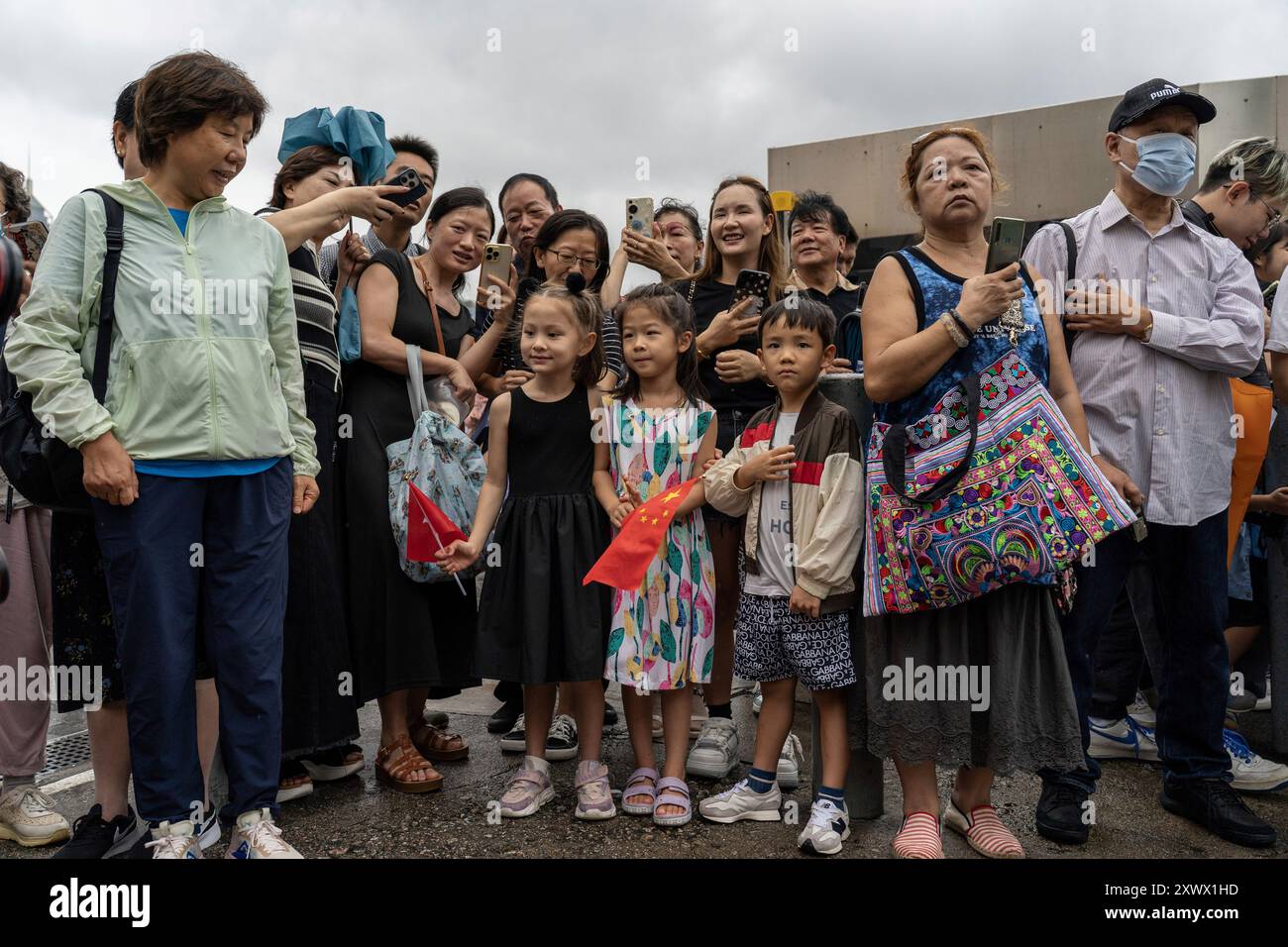 A crowd of people gather in Tsim Sha Tsui to greet Hong Kong's Olympic ...