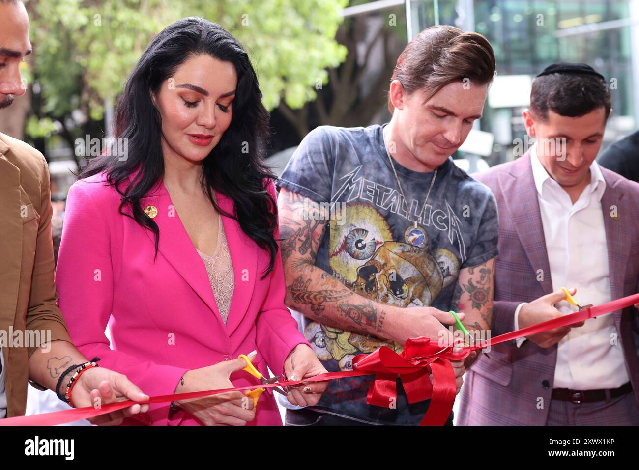 Gabriela Jimenez and Drake Bell are cutting the ribbon for the ...