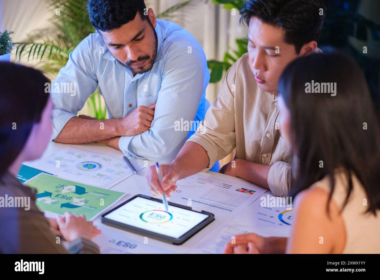 diversity team brainstorming focused on ESG (environment,social,governance) with tablet or sdgs ...