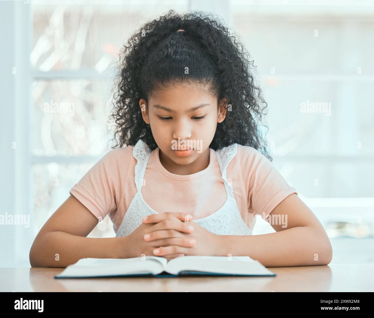 Girl, reading and bible at table in home with worship, spiritual prayer ...