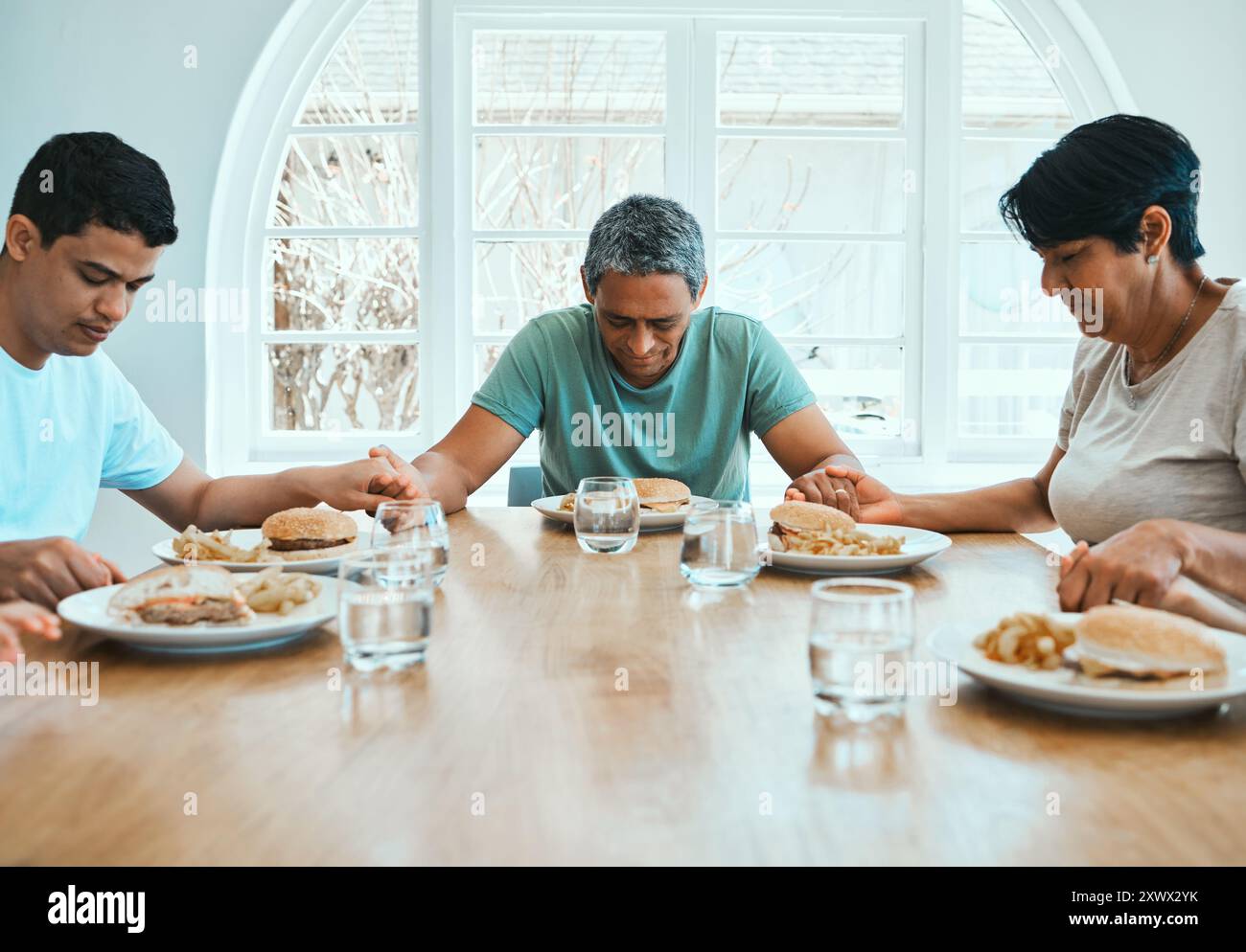 Praying, family and dinner in home, holding hands and grateful to God ...