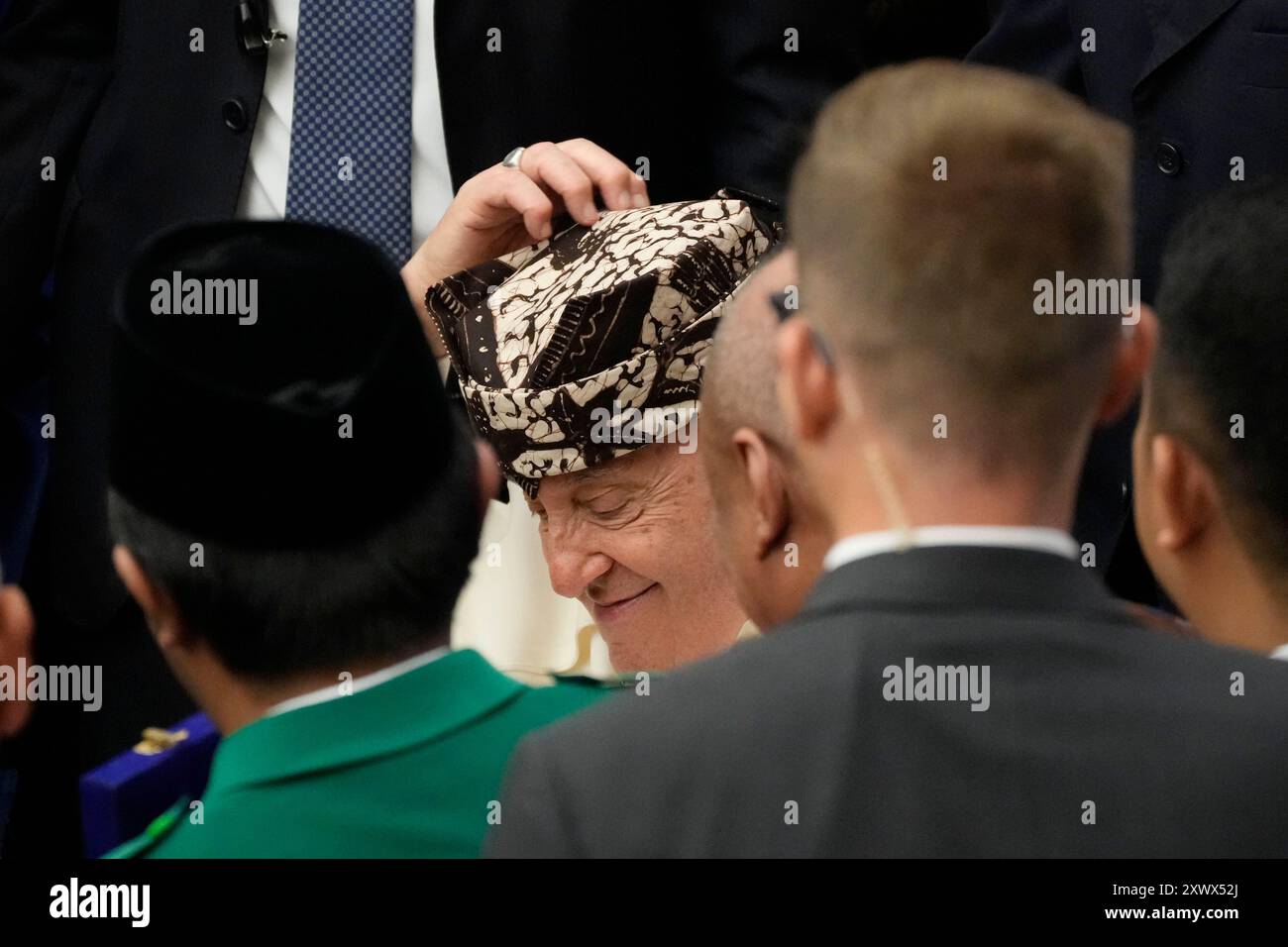 Pope Francis wears a traditional hat which was donated to him during a ...