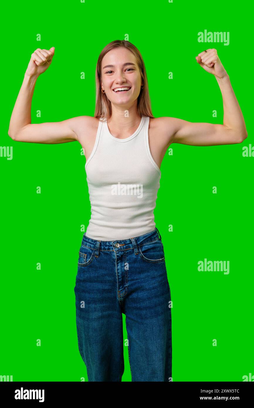 Young Woman In White Tank Top Flexes Biceps Against Green Screen Stock ...