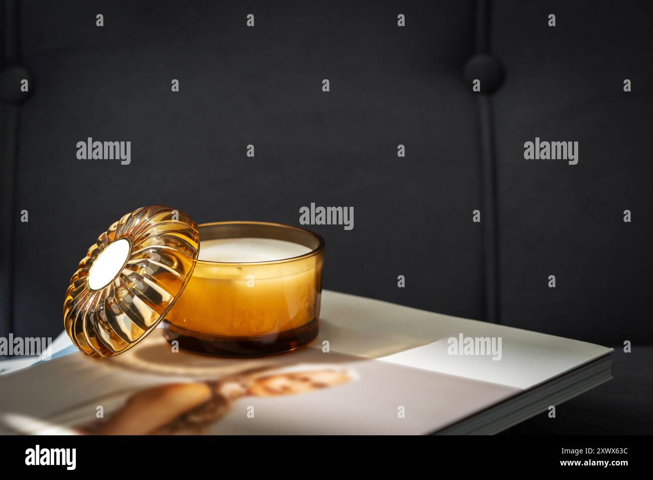 Amber Glass Candle Jar and Magazine on the couch Stock Photo - Alamy