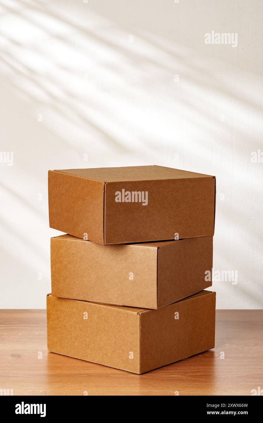 Three Cardboard Boxes Stacked on a Wooden Surface in a Room With ...