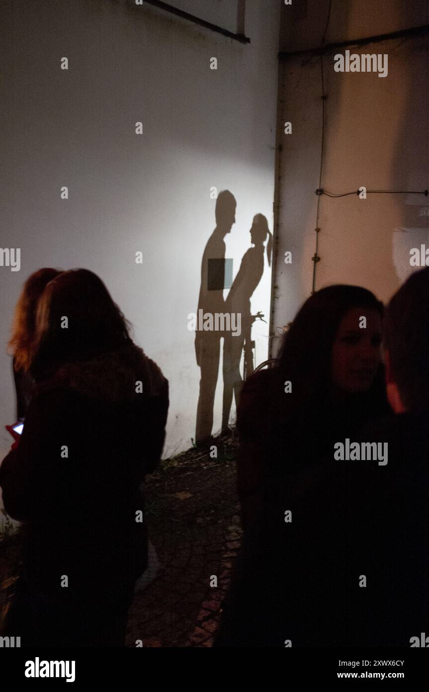 A romantic scene where a couple's shadow is cast on a wall, symbolizing ...