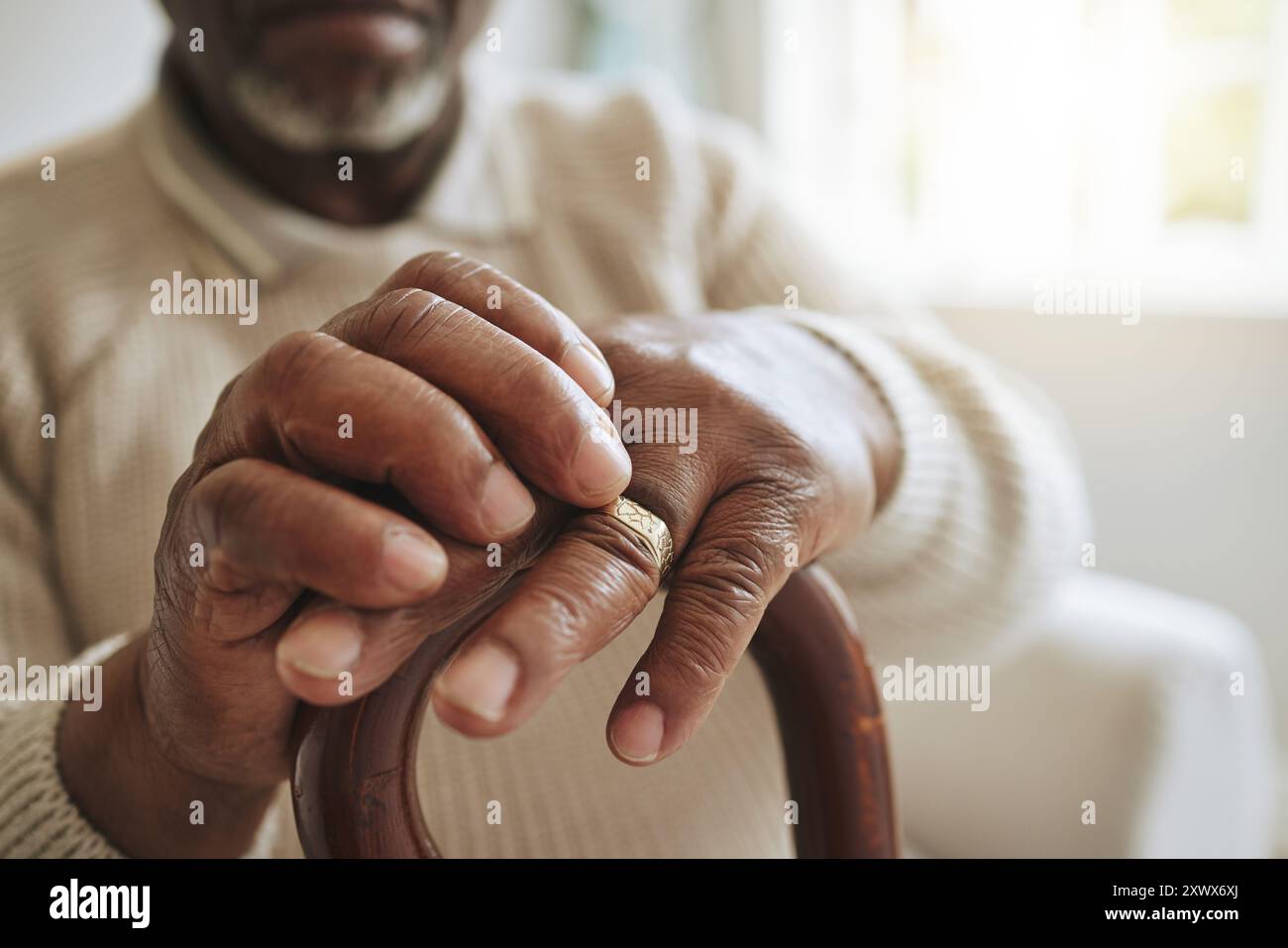 Hands, walking stick and wedding ring with senior husband closeup in home for grief, loss or ...