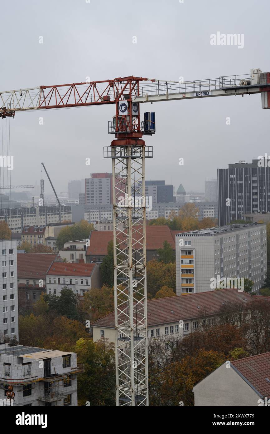 A construction crane rises above the rooftops of Berlin, symbolizing ...