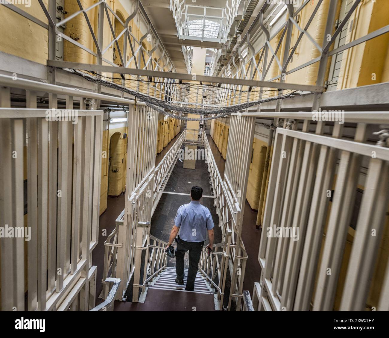 A prison guard walks through the historic and imposing hallways of ...