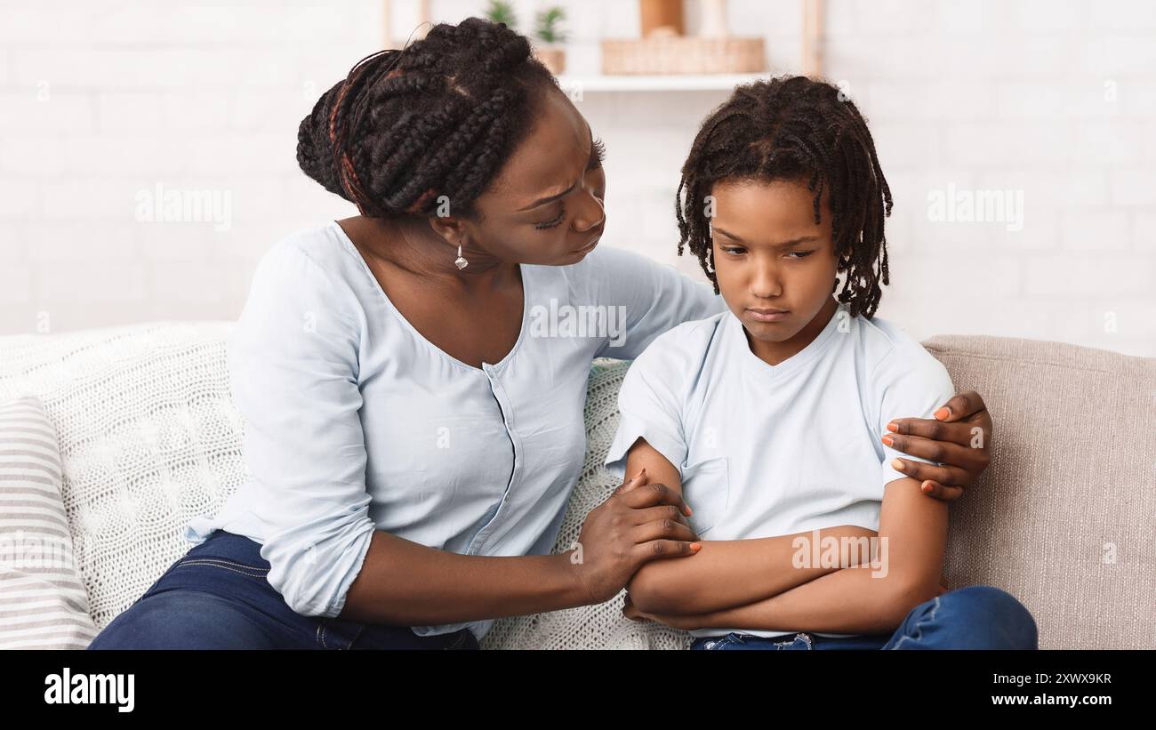 Black woman apologizing to her grumpy child Stock Photo - Alamy