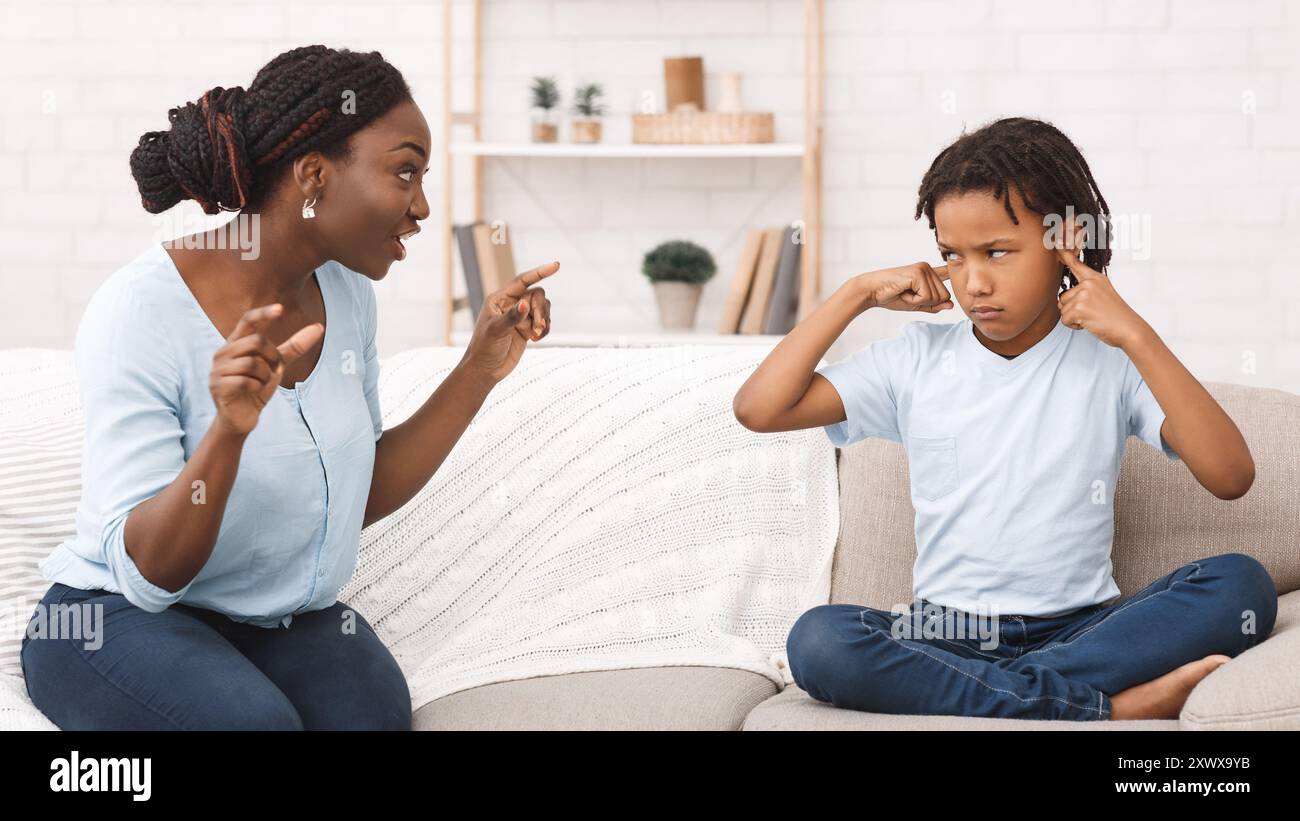Afro woman lecturing her child who closing ears Stock Photo - Alamy